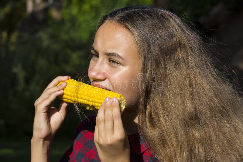 Girl eating sweet corn stock photo. Image of face, people - 76379104