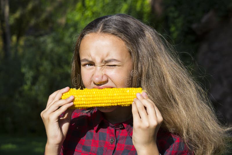 Girl eating sweet corn stock image. Image of eating, nutritious - 76379135