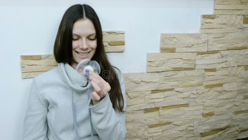 Girl Fiddling with Fidget Spinner while Sitting on the Floor Stock ...