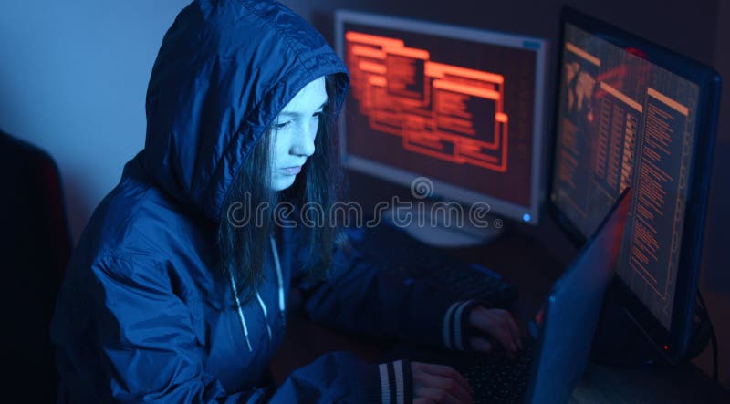Girl Hacker In A Hood Typing Program Code While Committing A Cybercrime Hacking A Firewall On