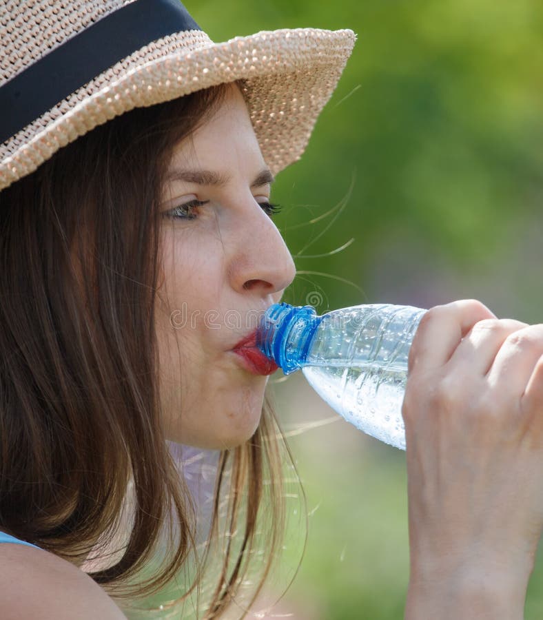 A Girl in a Hat Drinks Water from a Plastic Bottle Stock Image - Image ...