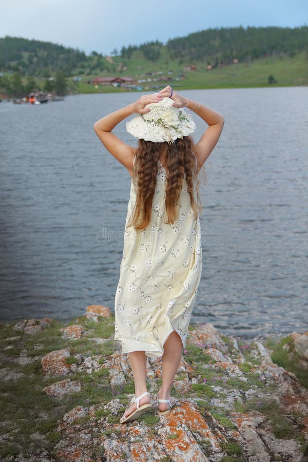 A Girl in a Hat Stands on the Shore of a Lake Stock Image - Image of ...