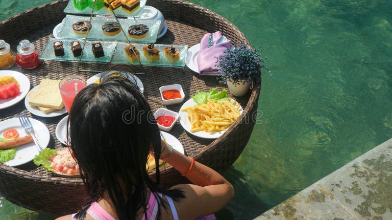 A Girl Having Breakfast Floating in the Pool Stock Image - Image of ...