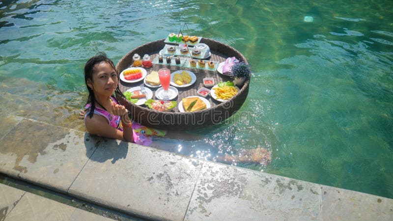 A Girl Having Breakfast Floating in the Pool Stock Photo - Image of ...