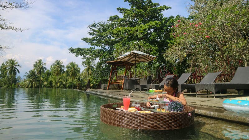 A Girl Having Breakfast Floating in the Pool Stock Photo - Image of ...