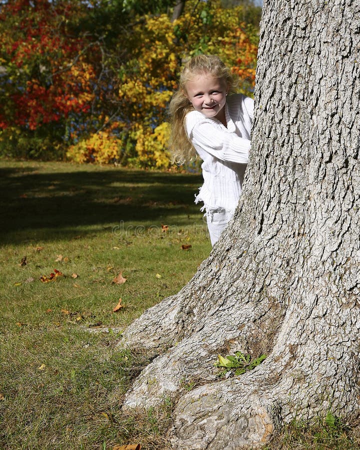 Girl hiding behind tree stock photo. Image of park, female - 3432360