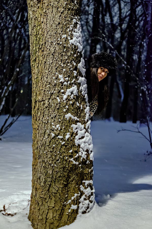 Girl Hiding Behind the Tree on a Snowy Evening Stock Photo - Image of ...