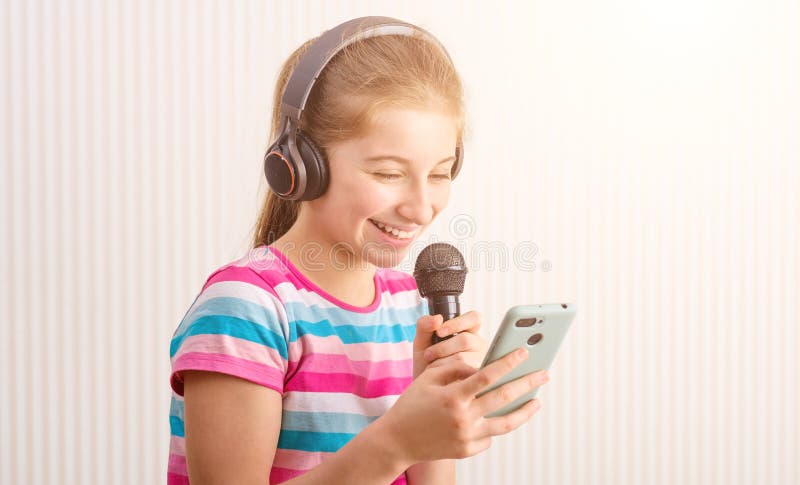 Girl Holding Phone in One Hand and Microphone in Another Stock Image ...