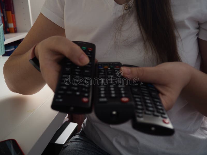 The Girl is Holding Several Remote Controls from the TV Stock Image ...