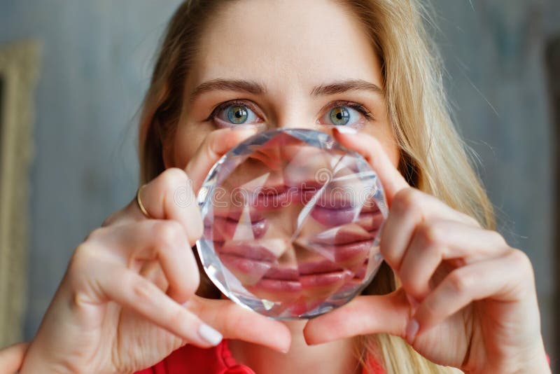 A Girl Holds a Crystal Crystal with Many Reflections in Front of Her ...