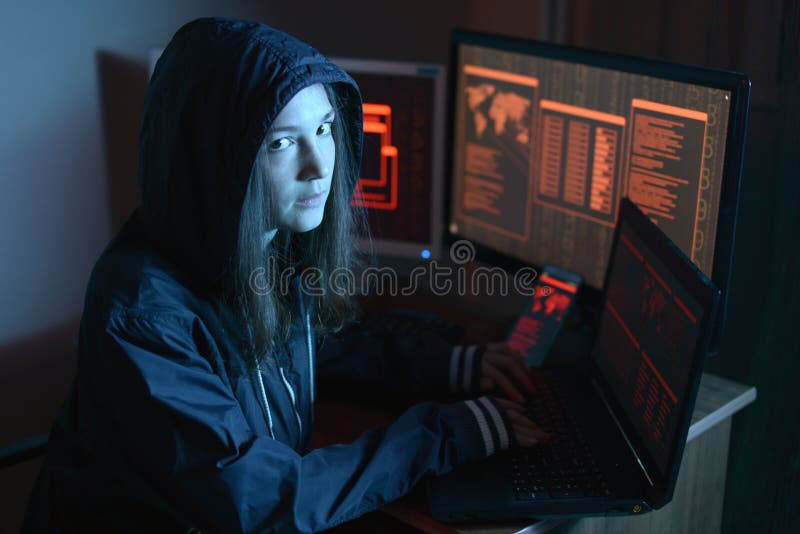 Girl In The Hood Looking In The Camera Hacker Attacks And Online Fraud On The Screen Background