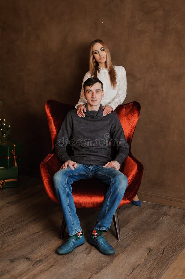 Girl Hugging a Guy Sitting on a Red Chair Stock Image - Image of ...
