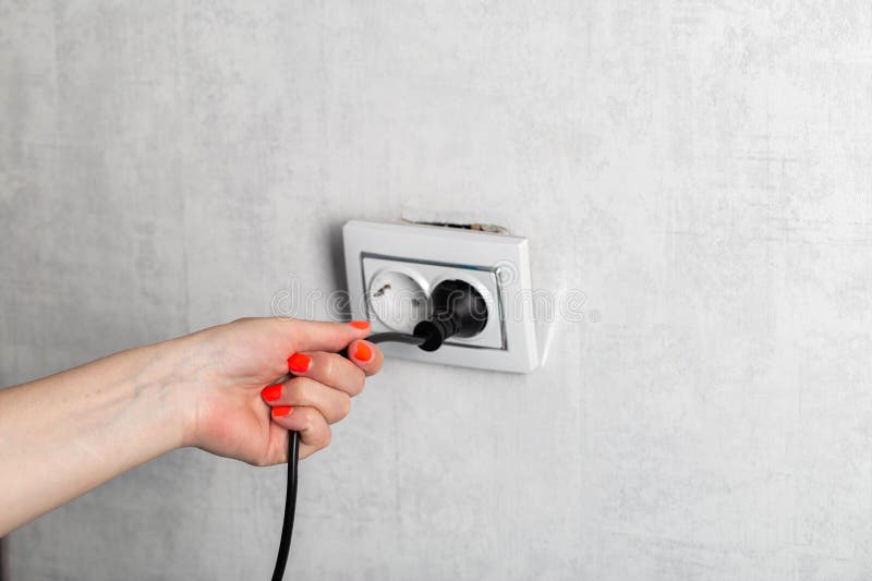 The Girl Removes the Electrical Plug from the Socket and Breaks the ...