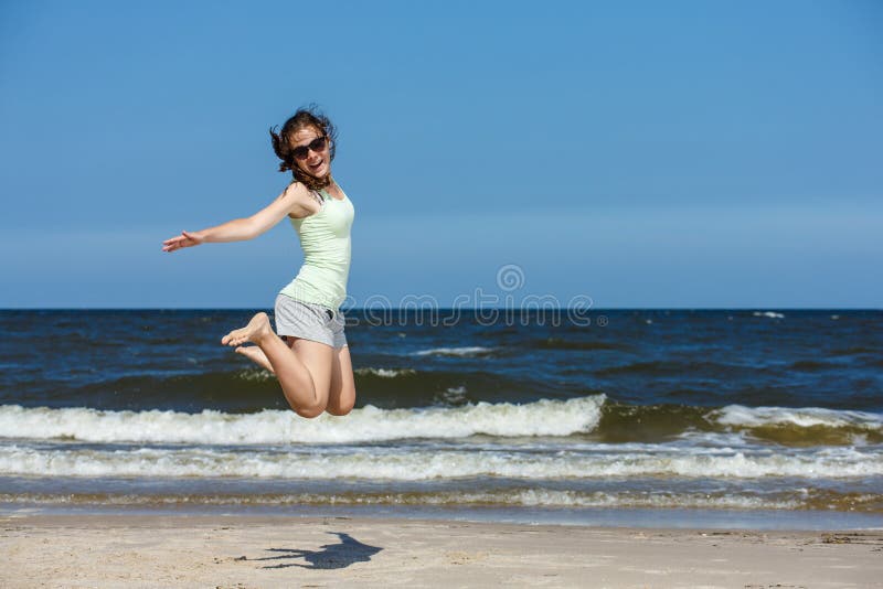 Girl jumping on beach stock photo. Image of moving, jump - 66126496