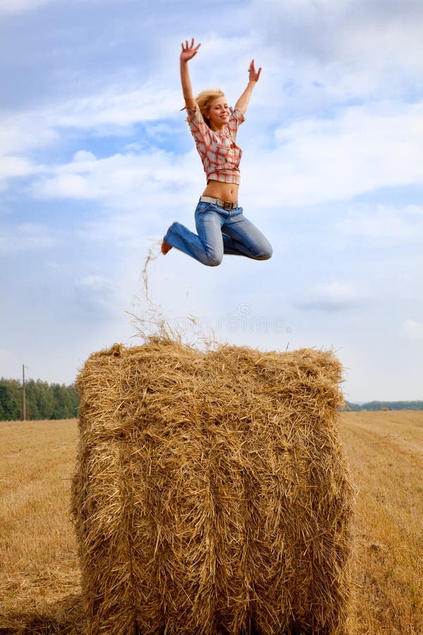 Girl Jumping Up on Straw Roll Stock Photo - Image of smiling, harvest ...