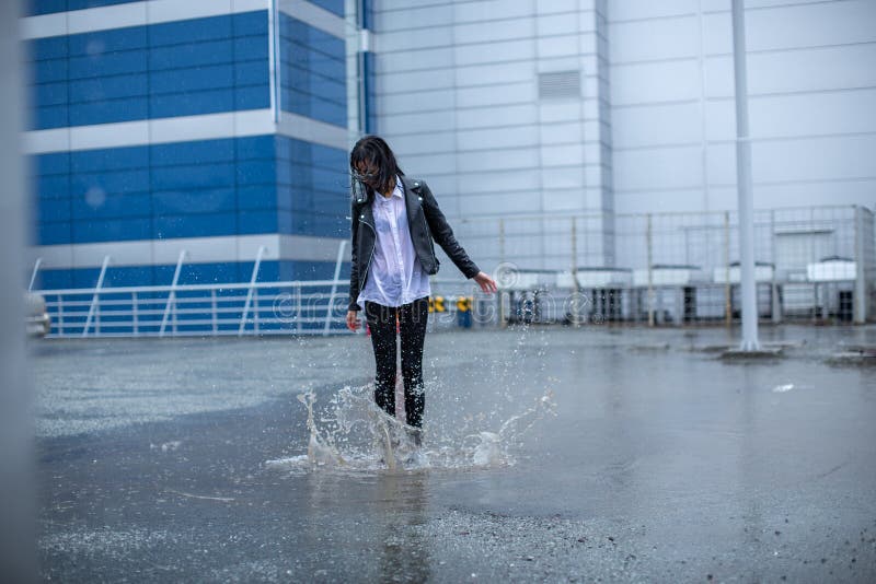 The Girl Jumps on a Huge Puddle. Stock Image - Image of instagirl ...