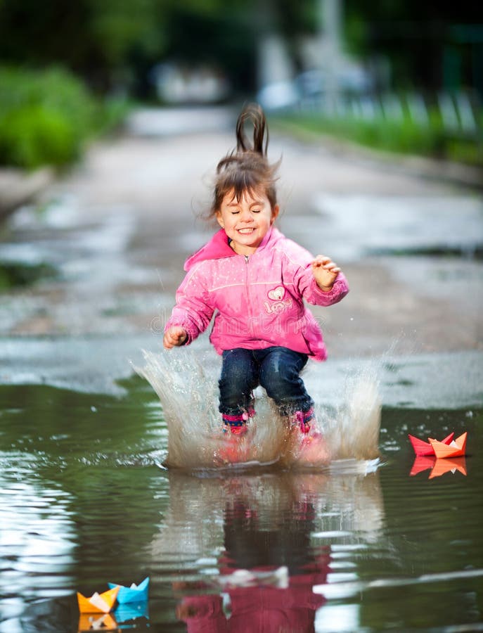 Girl jumps into a puddle stock photo. Image of messy - 25184534