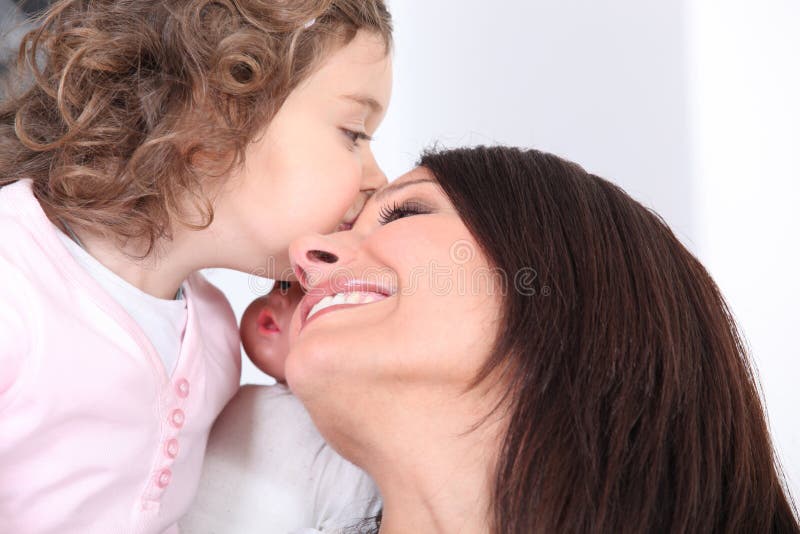 Daughter kissing mommy stock photo. Image of cheek, mother - 26934788