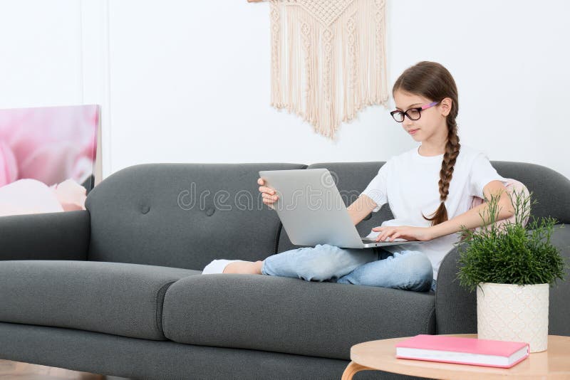 Girl with laptop on sofa stock image. Image of child - 225830021