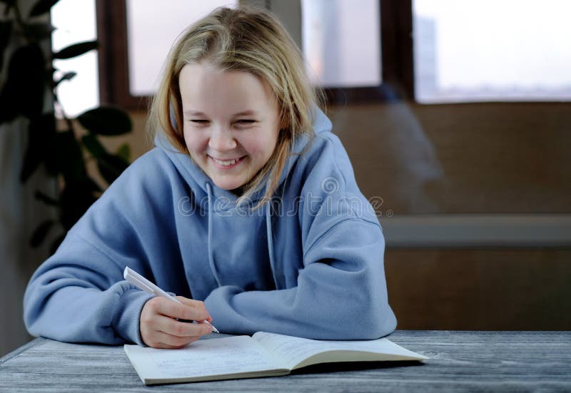 Girl Laughing and Writing Task with Pen in Copybook, Studing at Home ...