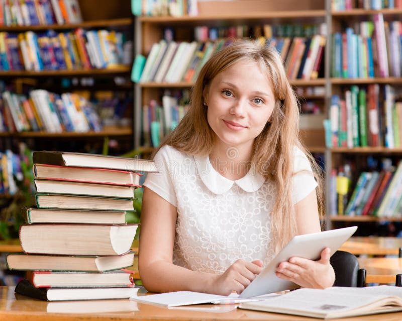 Girl Learning in Library and Reading E-book on Tablet Computer Stock ...