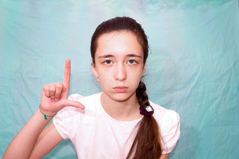 A Girl with a Long Braid Shows the Letter L with Her Hand Using the ...