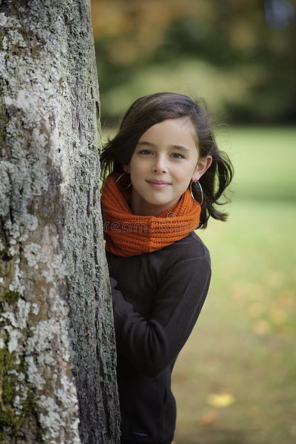 Two Little Girl Looking from Behind a Tree Stock Photo - Image of ...