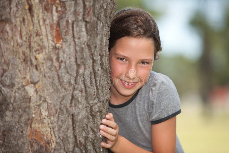 Girl Looking from Behind a Tree Stock Photo - Image of looking ...