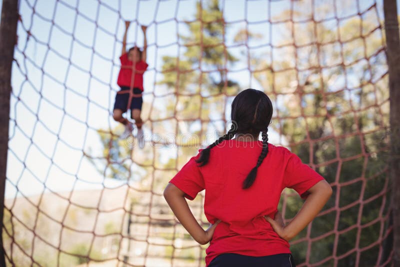 Girl Looking at Her Friend while Climbing Net during Obstacle Course ...