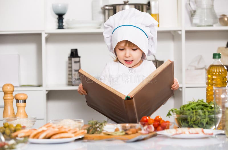 Girl is Looking Recipe in Culinary Book in the Kitchen Stock Image ...