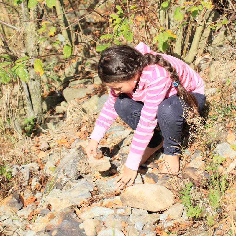 Girl looking for stones stock photo. Image of pink, plait - 34751816