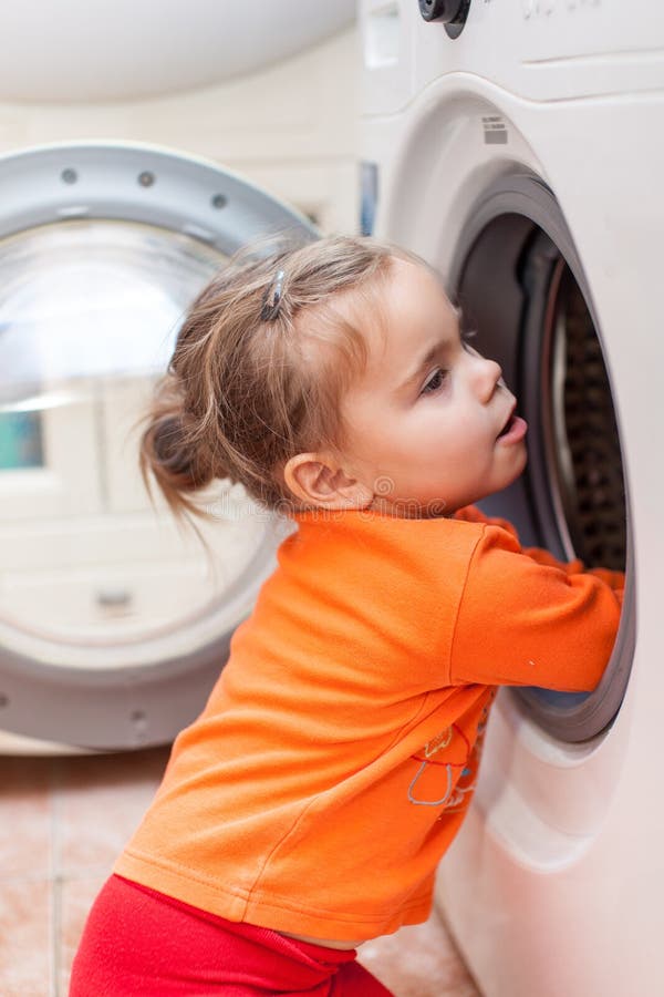 Girl is Looking into the Washing Machine Stock Photo - Image of ...