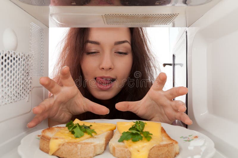 Girl looks in a microwave stock photo. Image of preparing - 22839082