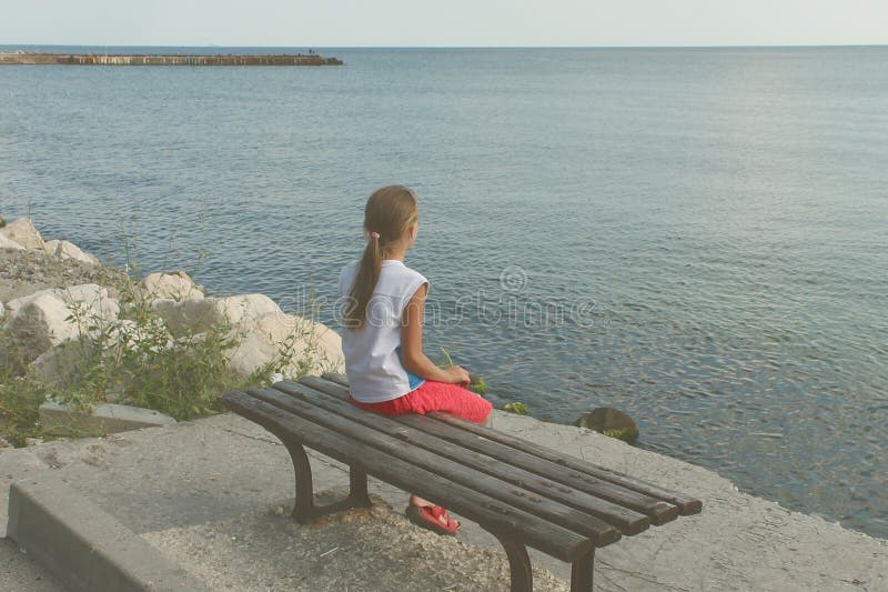 Girl Looks at the Sea Sitting on a Bench on the Beach Stock Image ...