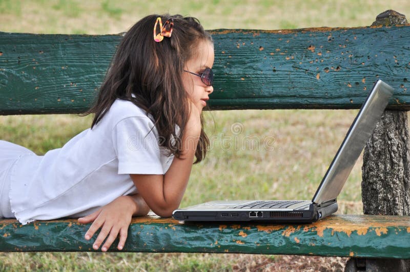 Girl Lying on a Bench with Computer Stock Photo - Image of learn, study ...
