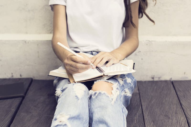 Girl Making Notes in the Diary and Sitting on a Wooden Floor Stock ...