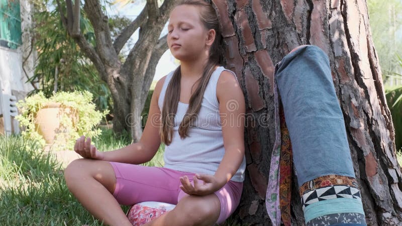 A Girl Meditates Under a Tree Stock Footage - Video of lotus, grass ...