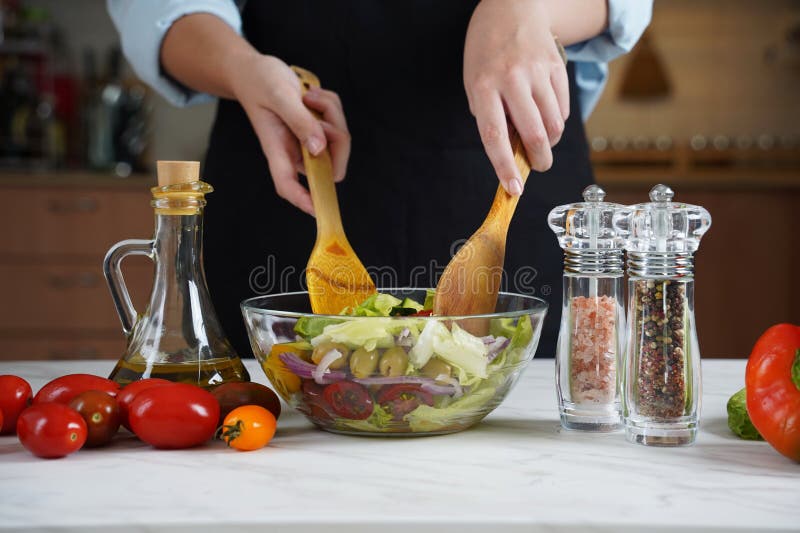 Girl Mixing Salad with Wooden Spoons. the Girl in the Process of Making ...