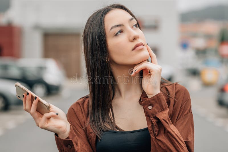 Girl with Mobile Phone with Expression of Thinking Stock Photo - Image ...
