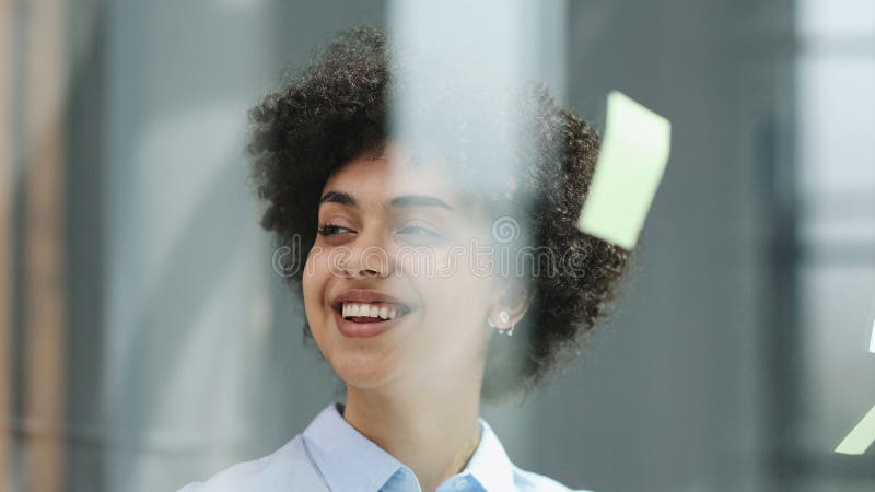 A Girl in a Modern Office Behind Glass Uses Sticky Notes and Makes ...