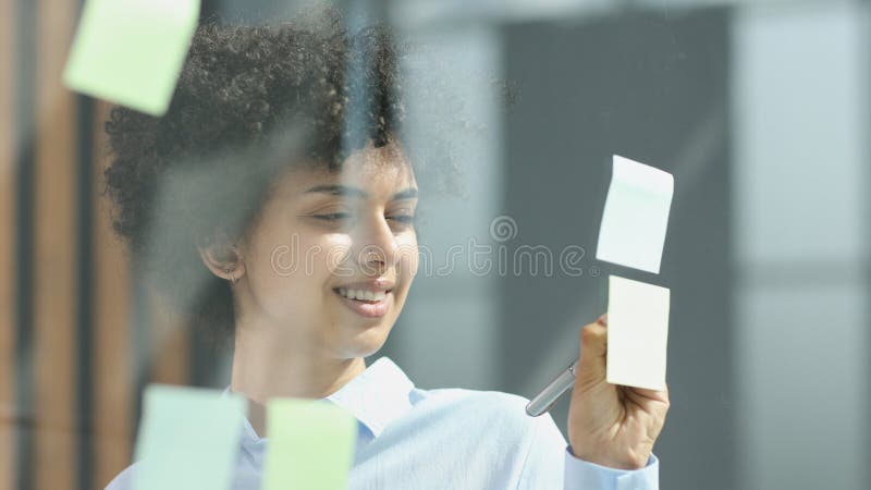 A Girl in a Modern Office Behind Glass Uses Sticky Notes and Makes ...