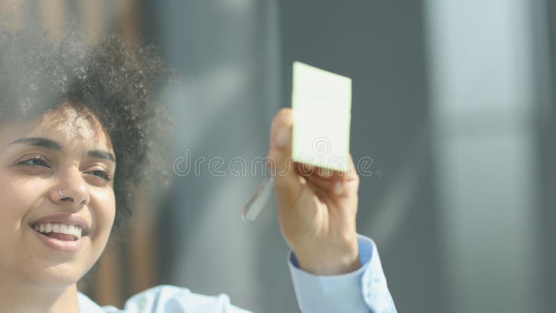 A Girl in a Modern Office Behind Glass Uses Sticky Notes and Makes ...
