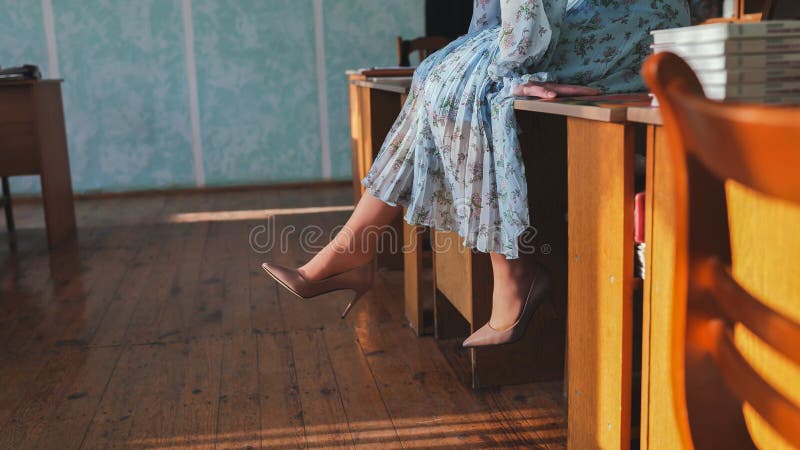 The Girl Moves Her Legs Sitting on the Table. Stock Photo - Image of ...