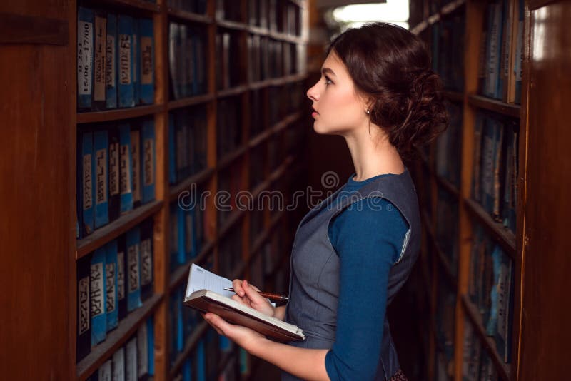 Girl with Notebook Select Textbook in Library. Stock Photo - Image of ...