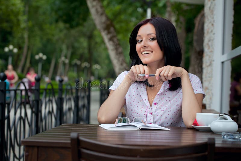 Girl with notepad in cafe stock image. Image of paper - 16216227
