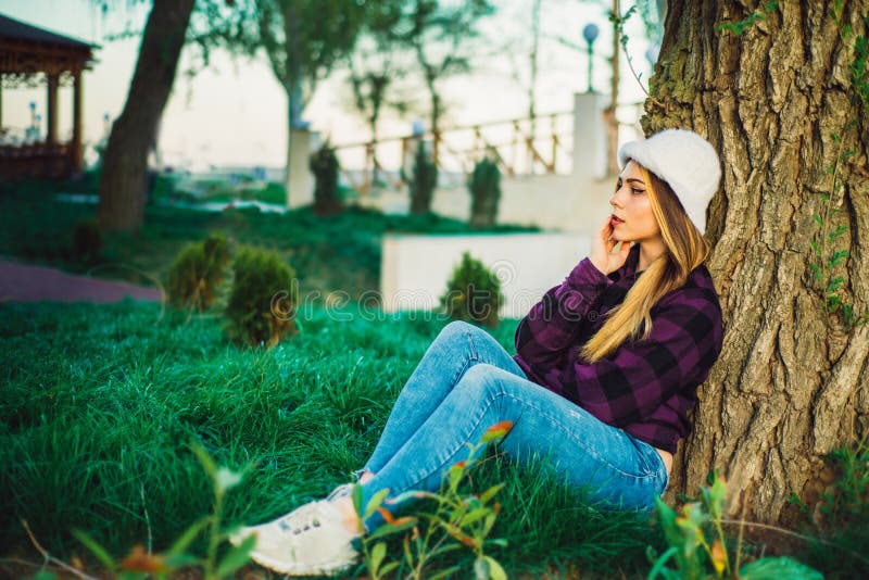 Blonde Girl in the Park Sitting Under a Tree Stock Photo - Image of ...