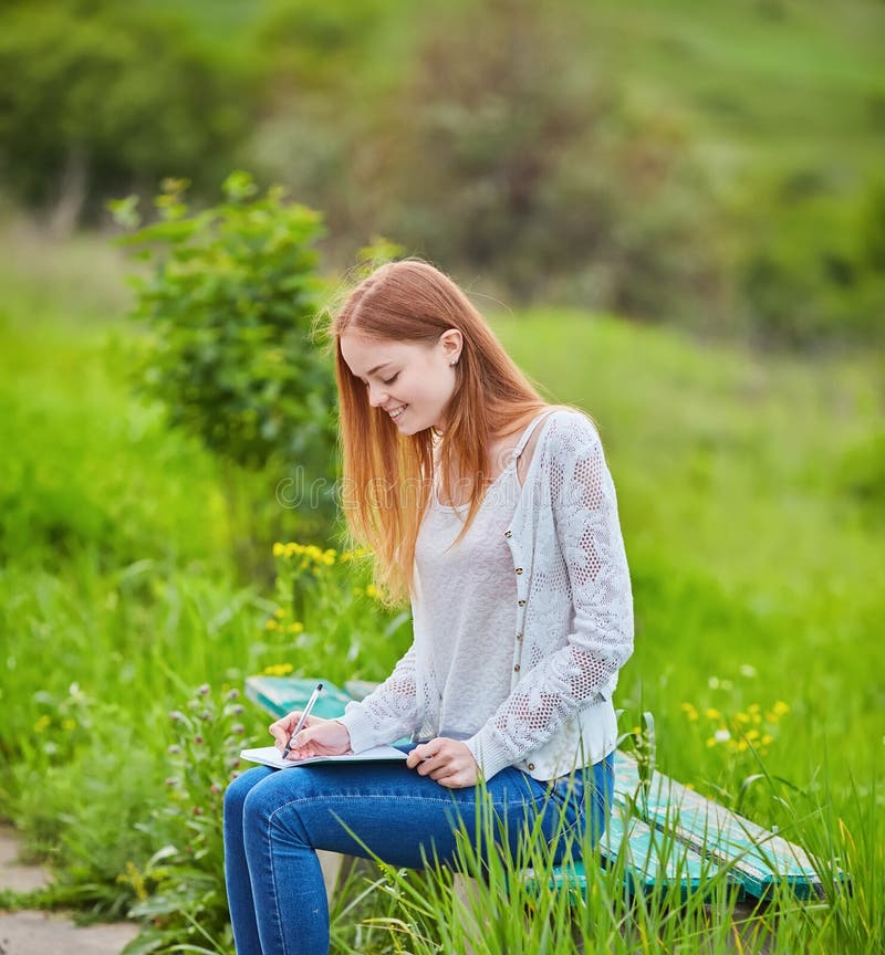 Girl with Pen Writing on Notebook on Grass Outside Stock Image - Image ...