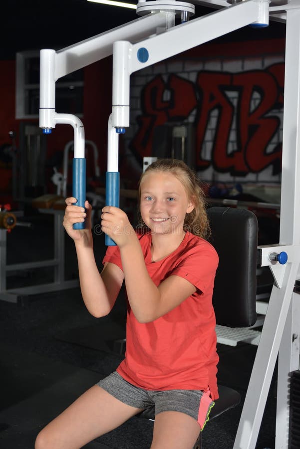 The Girl Performs an Exercise on the Simulator in the Gym. Reduction of ...