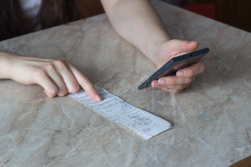 A Girl with a Phone Counts Expenses in a Check, Close-up Calculation ...