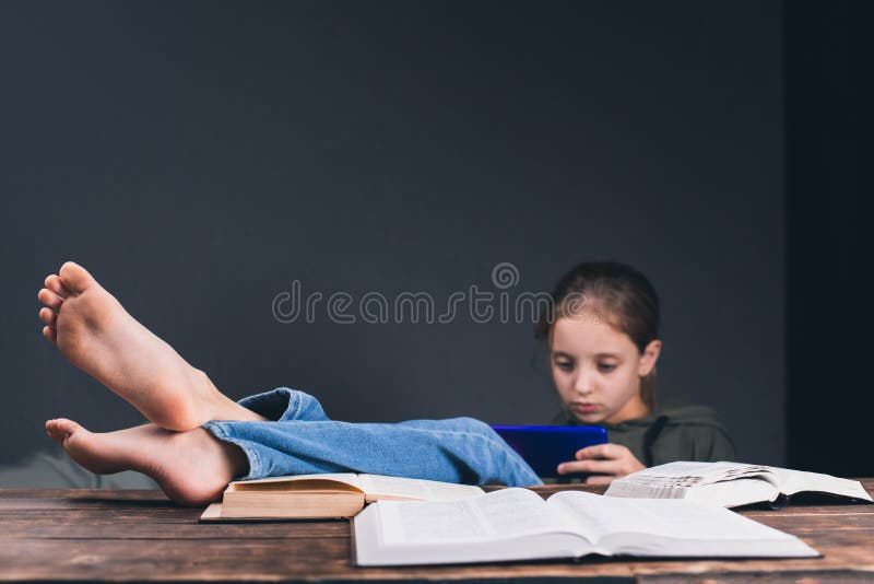 A Girl with a Phone in Her Hands. the Girl Plays on the Phone, Ignoring ...